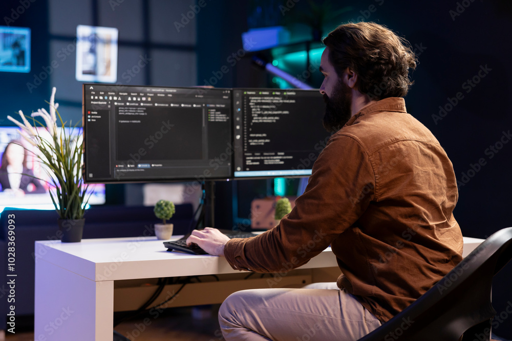 IT admin working from home developing software in JavaScript programming language using desktop ...