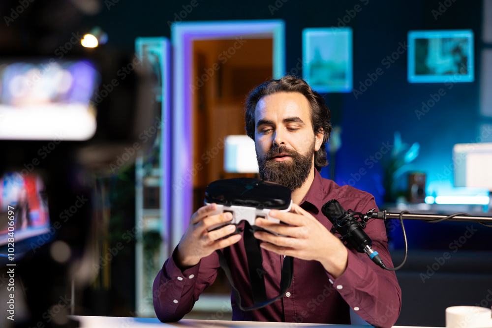 Foto de Smiling man presenting VR goggles to audience, filming video ...