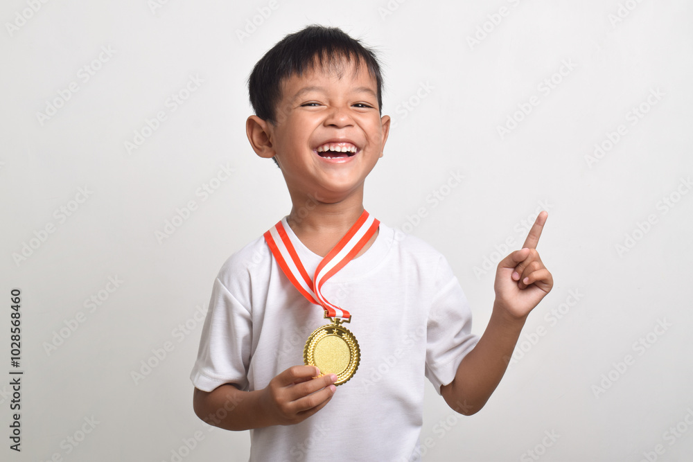 Little asian boy raising his finger showing the first place gold medal ...
