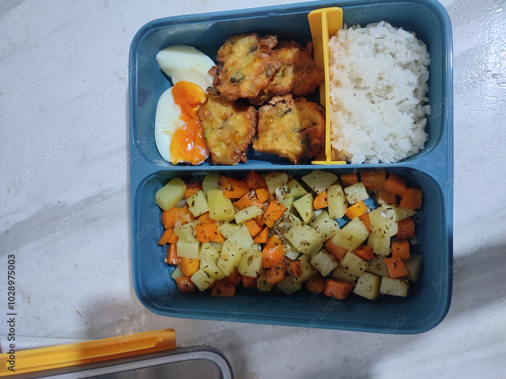 A healthy lunch box with a variety of foods. The lunch box contains a ...