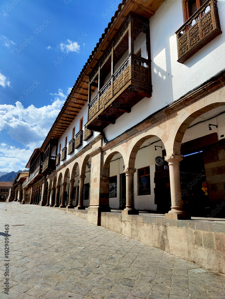 Fachada colonial con balcones de madera y arcos en una plaza histórica ...