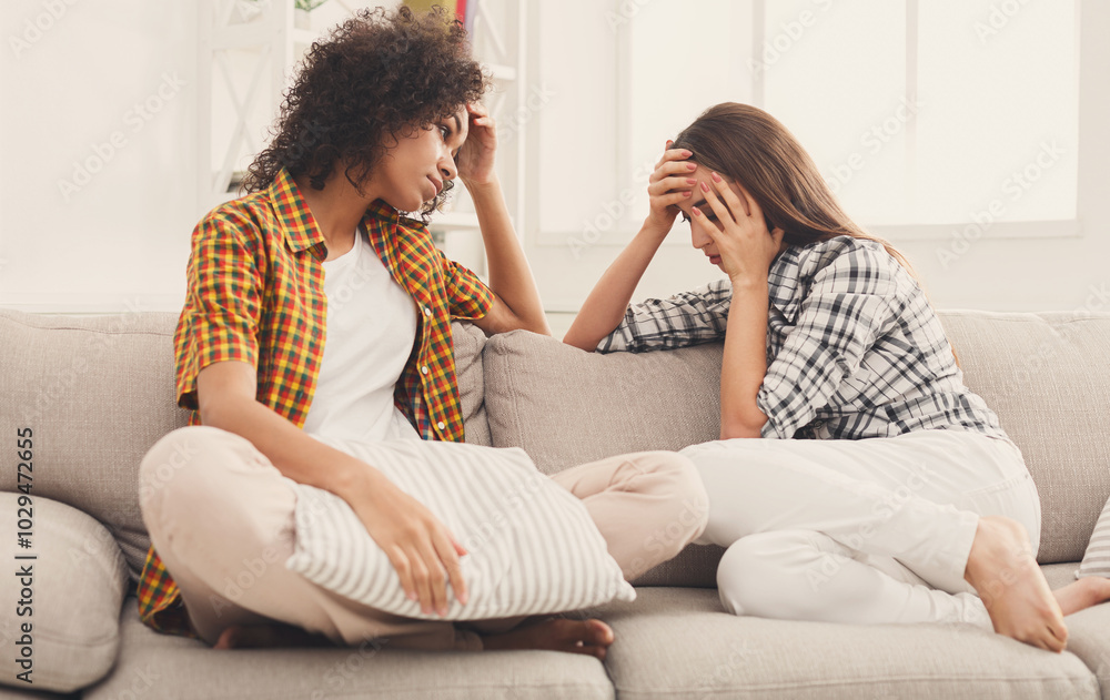 Two sad diverse women talking at home. Female friends supporting each ...