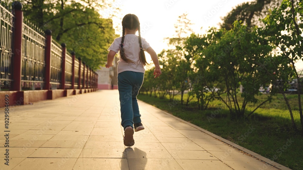 little child run along path park. running kid girl summer city sunset ...