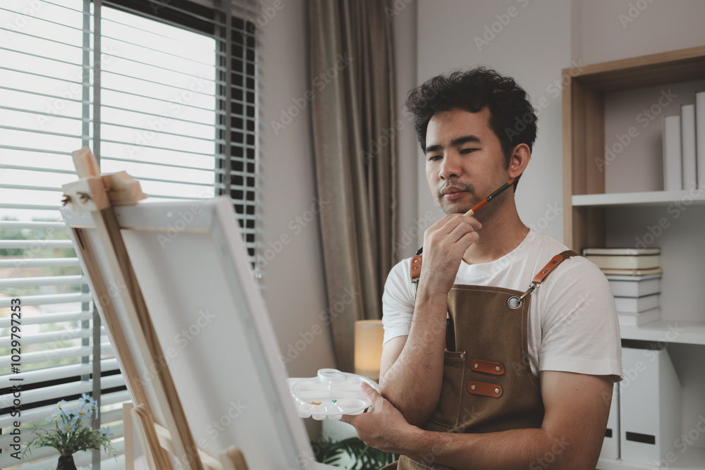 a painter is in his painting studio, a rising male artist is focusing ...