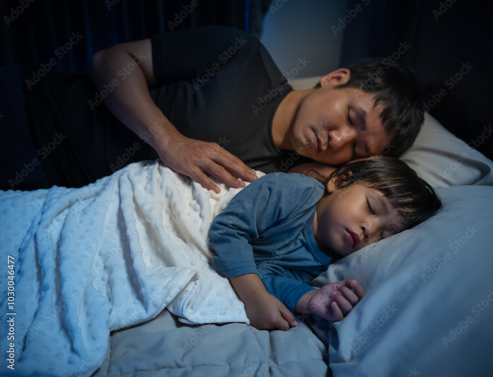 father embraces the toddler baby sleeping together in bed at night Stock Photo | Adobe Stock