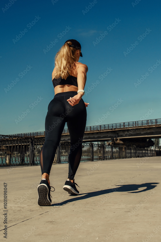 athletic woman with beautiful toned legs starts running along the ...
