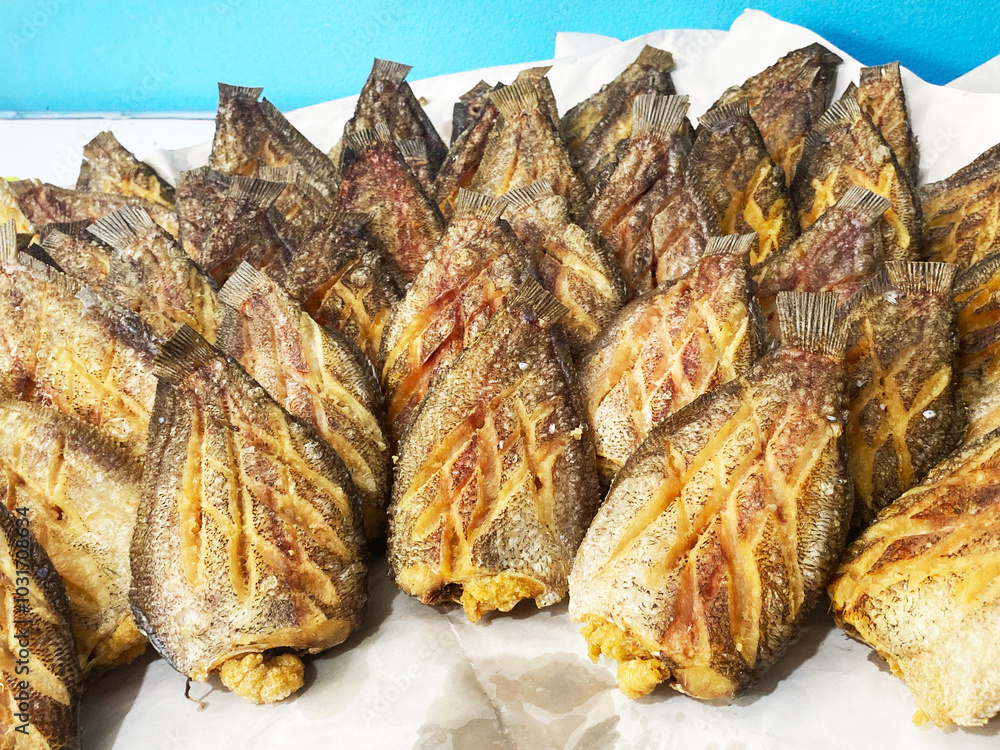 Deep fried Snakeskin gourami fish with spawns on white arches oil paper ...