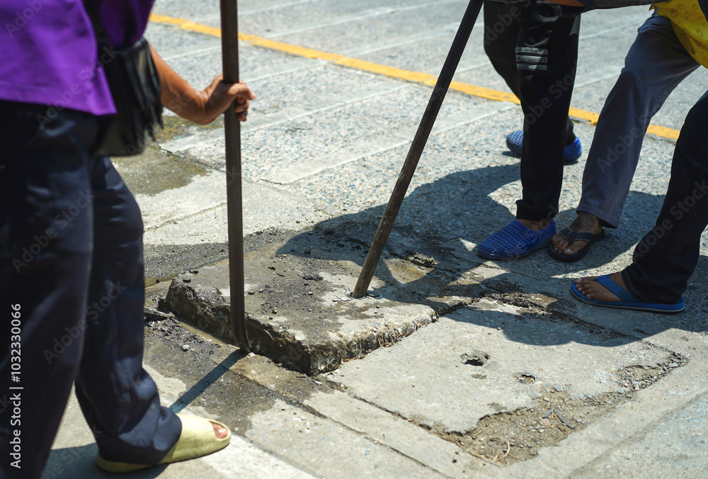 Workers hands using steel crowbar open concrete sewer lid on road for ...