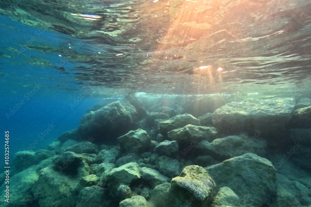 Shallow sea, big stones with sunrays. Light in the murky sea and sea ...