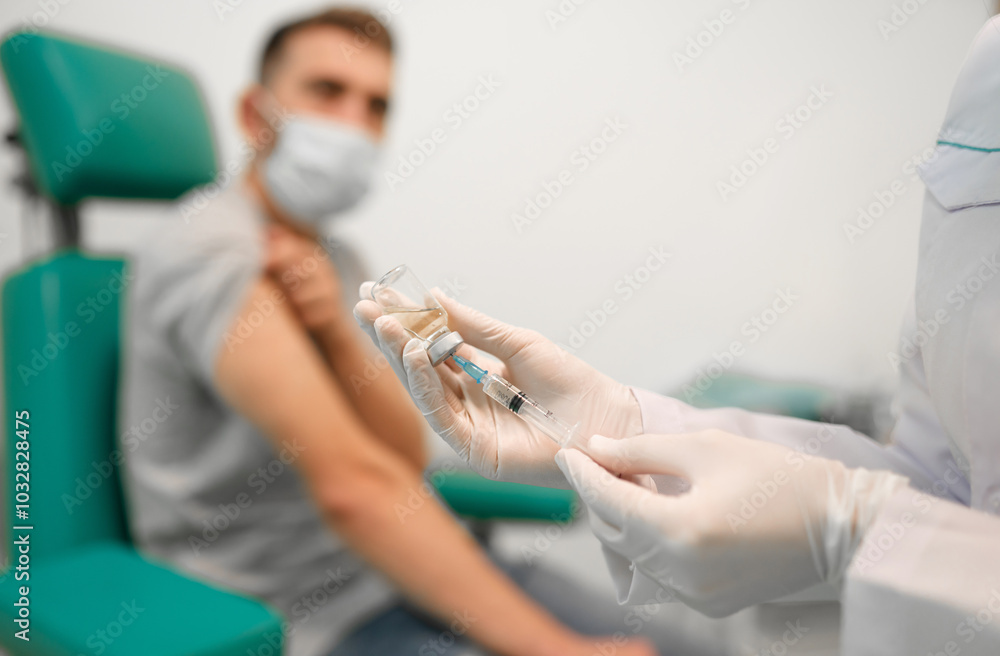 Healthcare professional prepares a syringe with a vaccine, while a ...