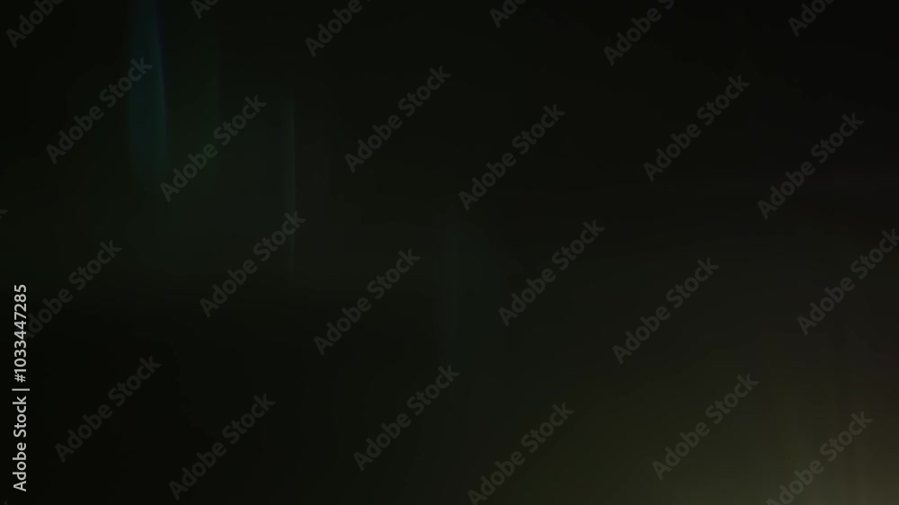 An anamorphic lens flare glides from left to right across a dark ...