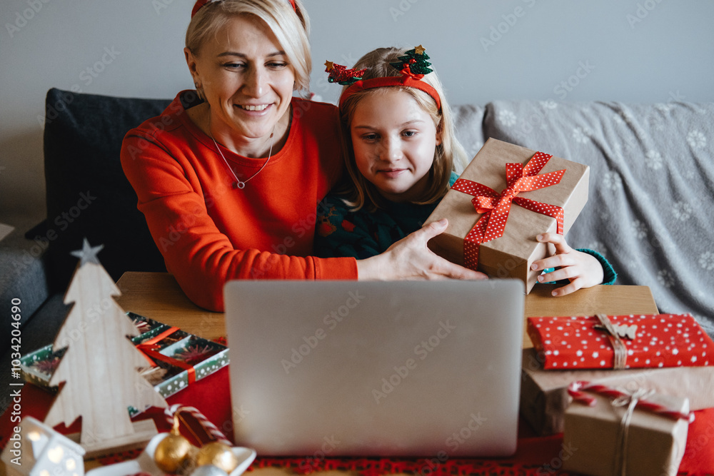 Mother and daughter celebrating Christmas virtually with loved ones. Virtual celebrations ...