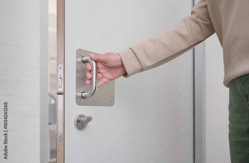 Hand of an unrecognizable woman pulling the handle of the sliding door ...