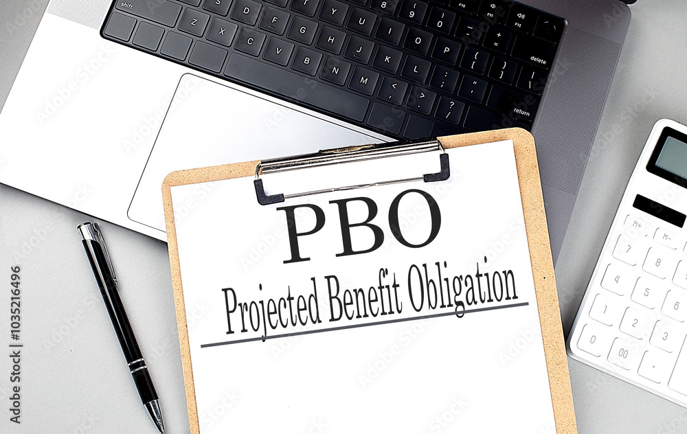 PBO projected benefit obligation document on a clipboard with a laptop ...