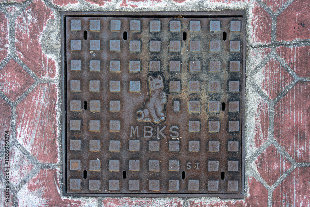 Poster Manhole cover to Storm water drain marked "MBKS" meaning "Majlis Bandaraya Kuching ...