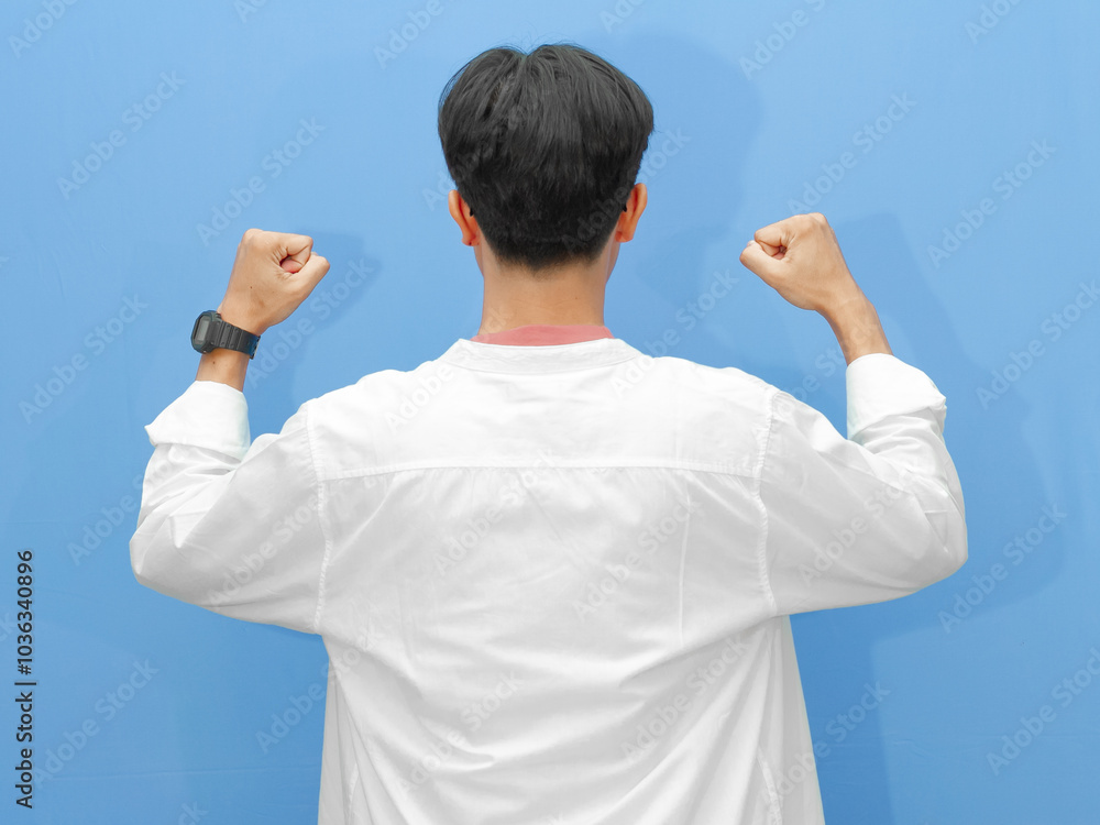 Back view of an Asian man in casual clothes, clenching fists and ...