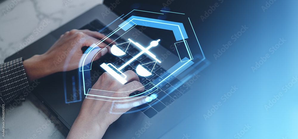 Hands typing on laptop with justice scale icon hologram overlay on blue ...