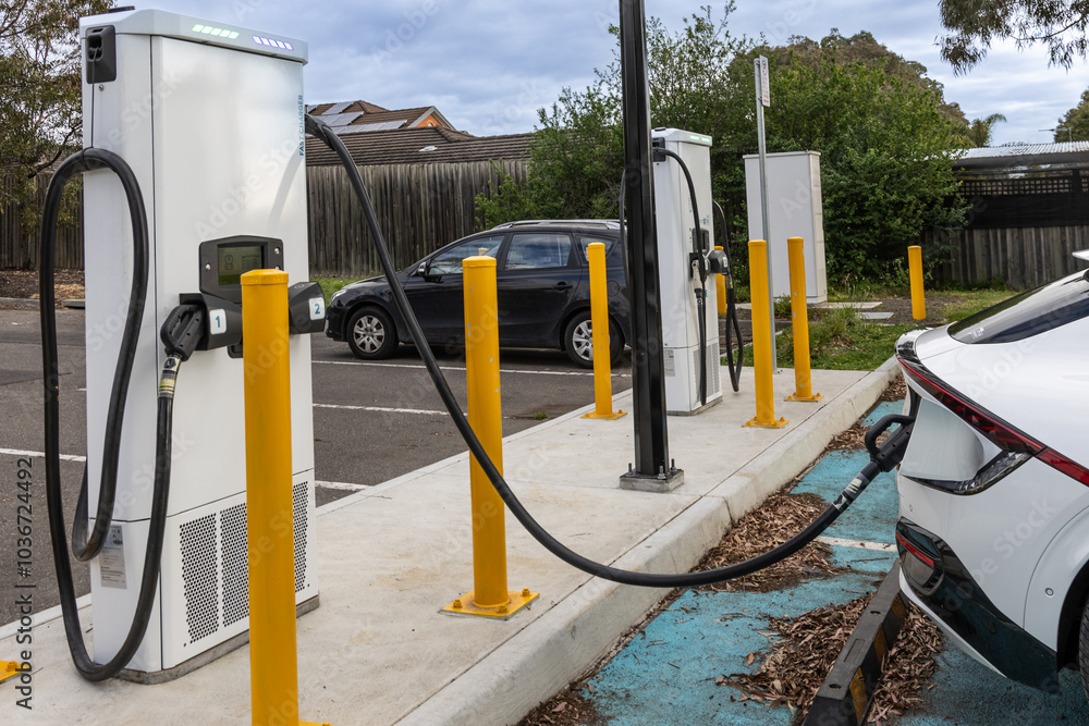 EV car plugged in with fast charger at charging station to refuel ...