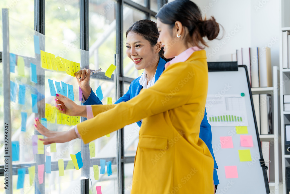 Foto de Dynamic Duo Brainstorming: Two smiling businesswomen ...