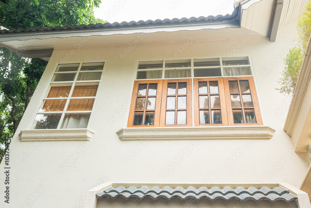 Cozy house exterior with wooden casement window and white wall ...
