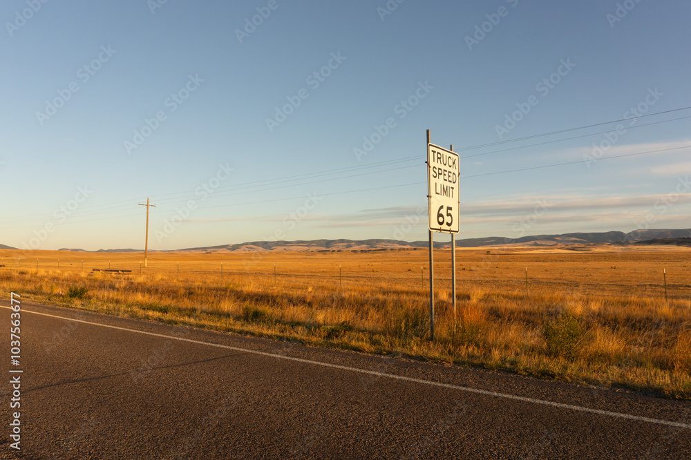 Truck speed limit highway sign, road signage at sunrise, western ...