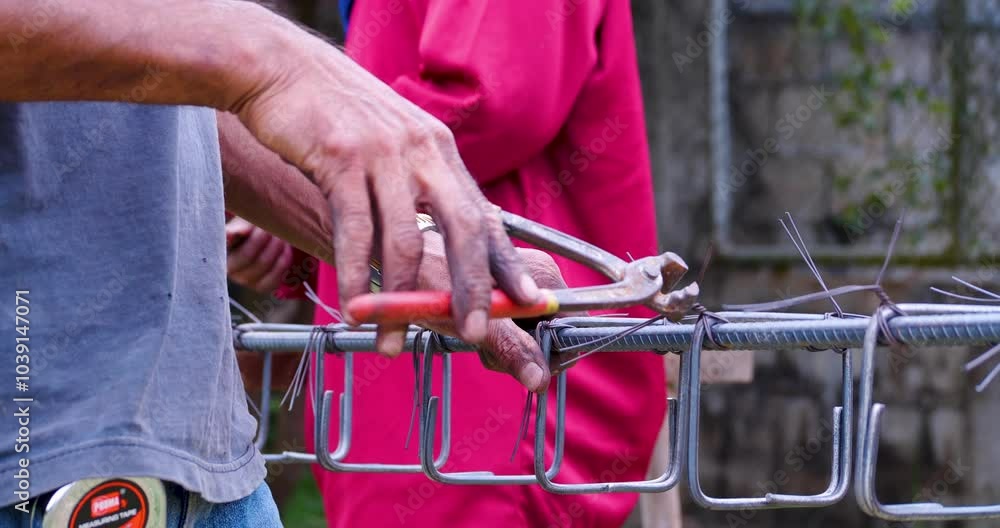 Men hands using pincer pliers iron wire reinforcement of concrete work ...