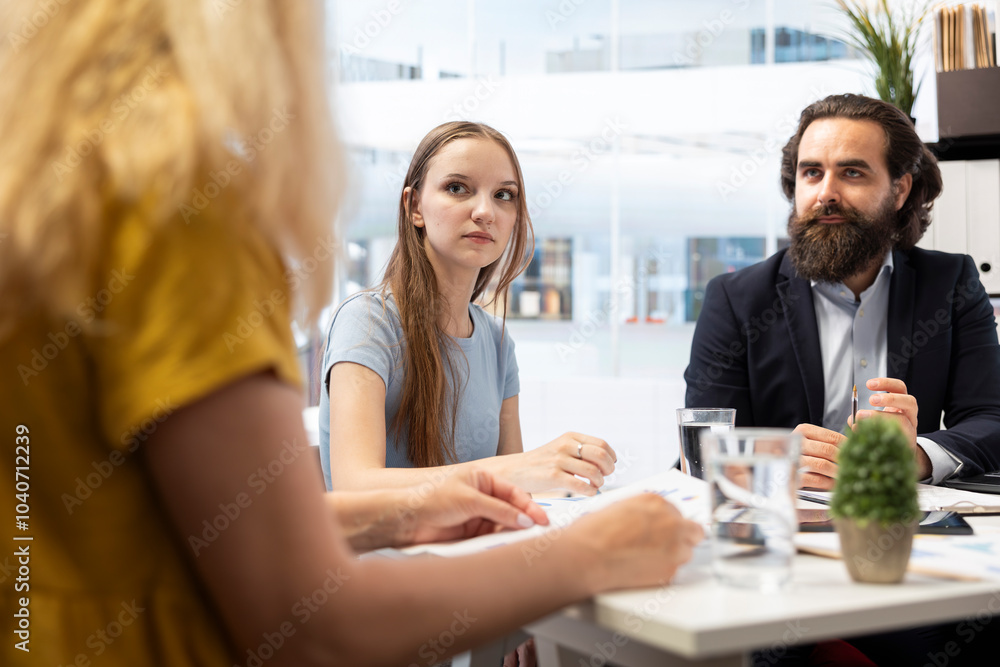 Financial advisors meeting with clients to counsel them on their ...