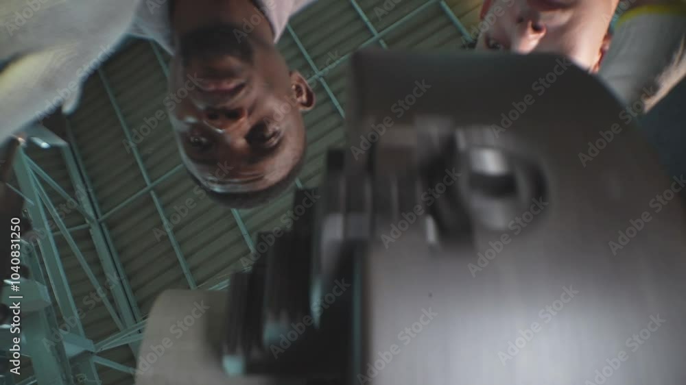 Engineer focused on operating a lathe machine, adjusting precision ...