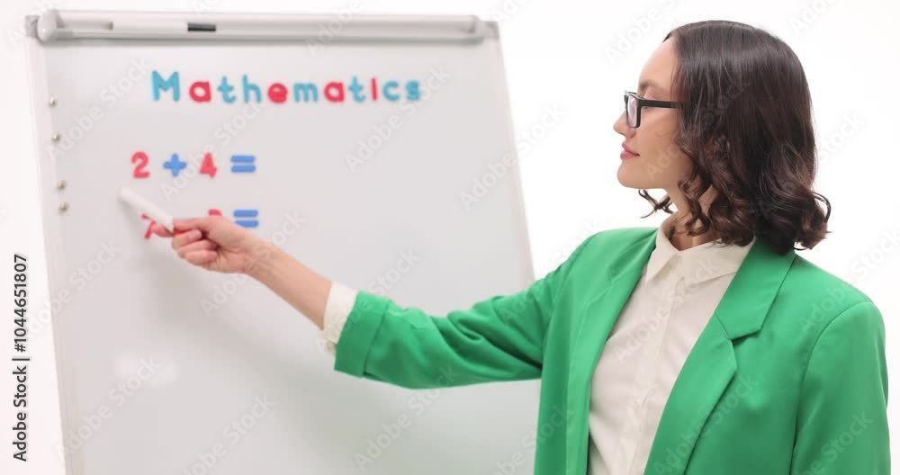 Woman teacher explains math exercise on whiteboard in classroom. Lady ...