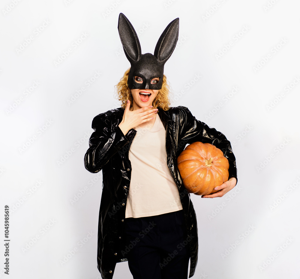 Halloween girl in bunny costume with Halloween pumpkin. Smiling bunny ...