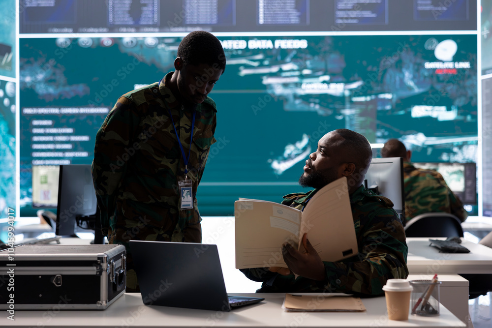 Military experts in an operations center handle satellite data details ...