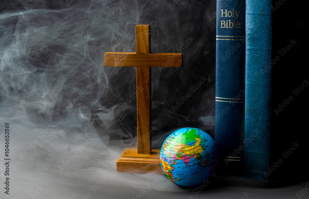 Religion cross and book of Holy Bible with globe. It is laying on table ...