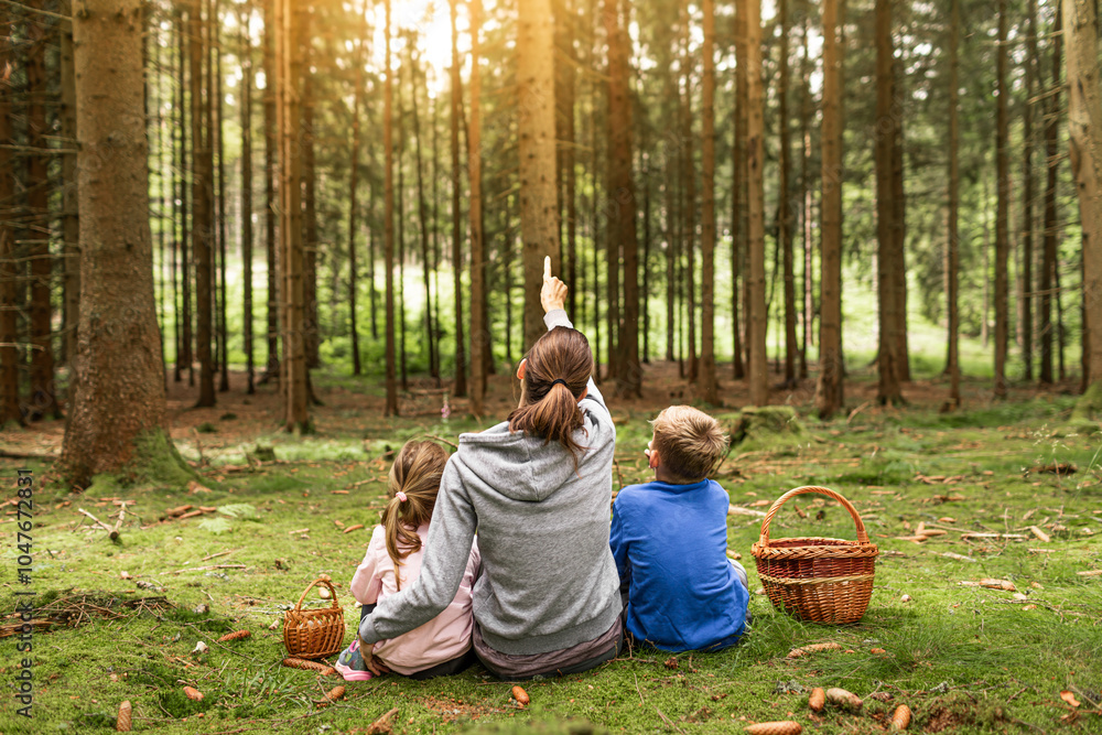 Happy single mother and her children siting together in nature forest ...