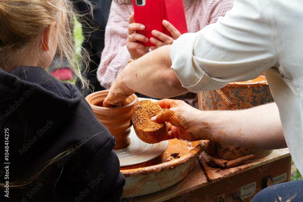 Pottery training. Rotating a clay pot on a machine. Hands knead clay ...