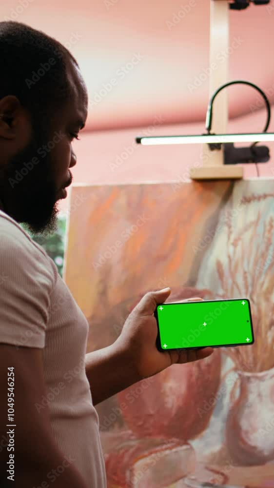 Vertical Video Young artist looking at isolated chroma key display in ...