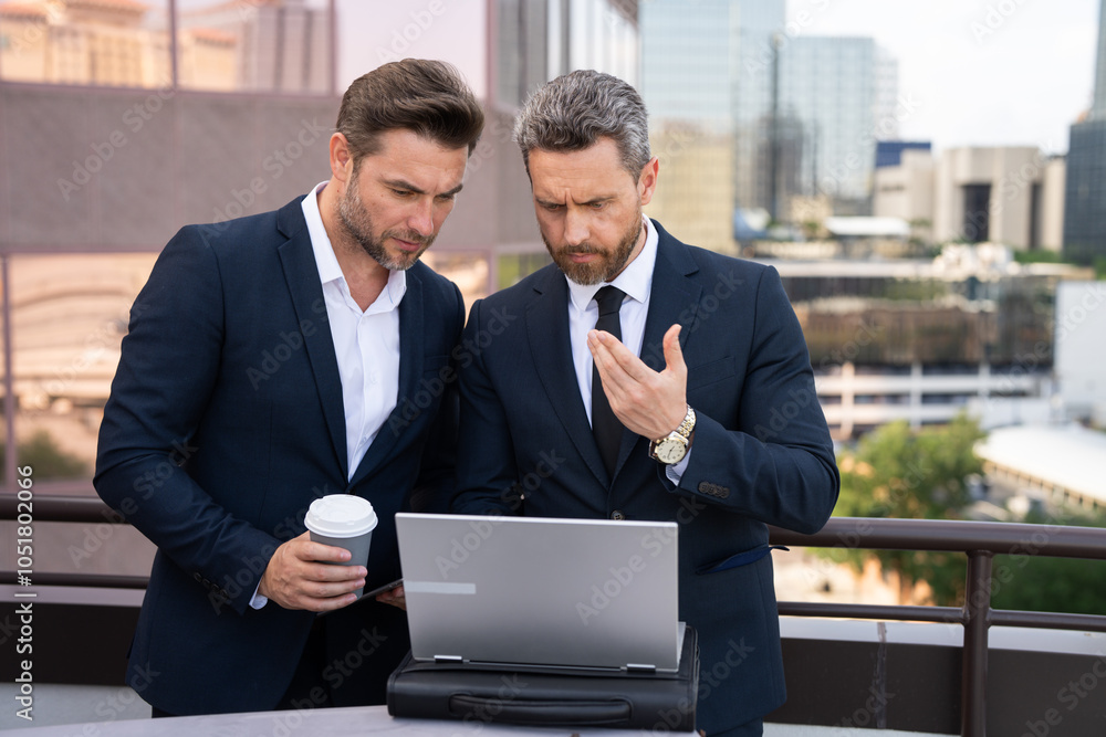 Two businessman on the street, deeply engrossed, eyes fixed on their ...