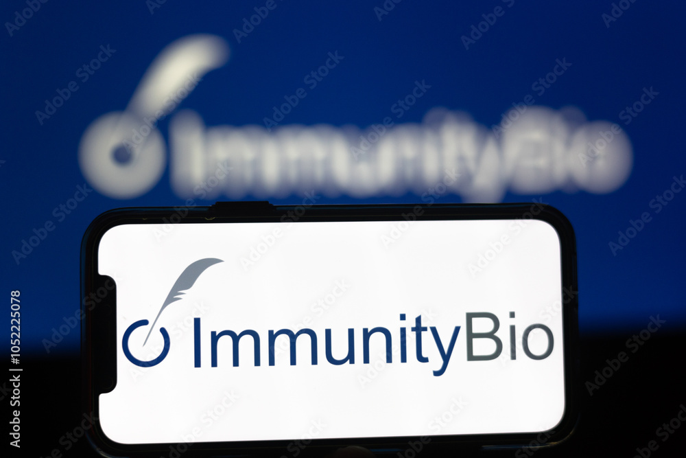 Silhouette of Hand Holding iPhone with ImmunityBio Logo in Front of ...