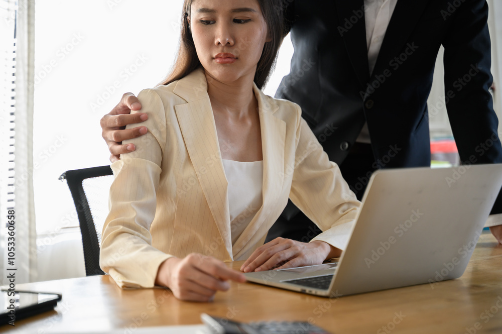 A male colleague or supervisor places a hand on the shoulder of an ...