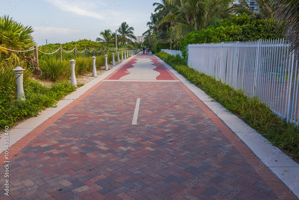Paved walking path lined with greenery and lamp posts along Walking ...
