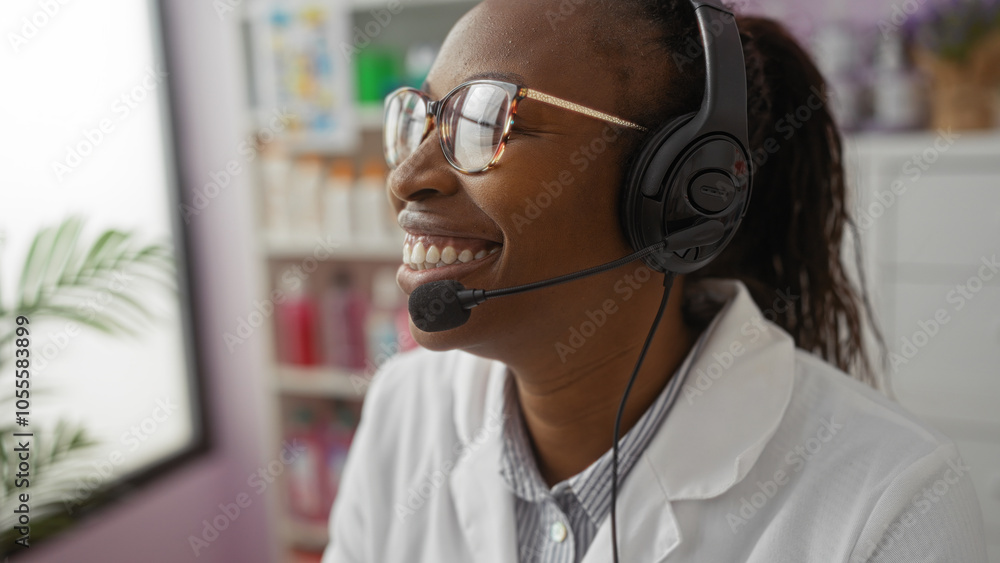 Woman talking through headset in a pharmacy, smiling and wearing a lab ...