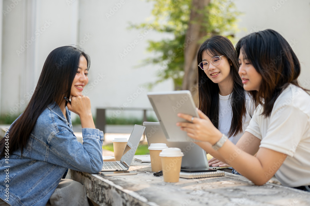 Group of Asian female college students is working on a project together ...
