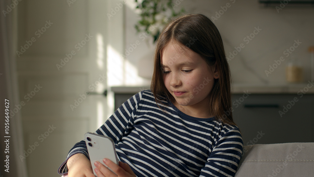 Caucasian little girl holding mobile phone smartphone scrolling ...