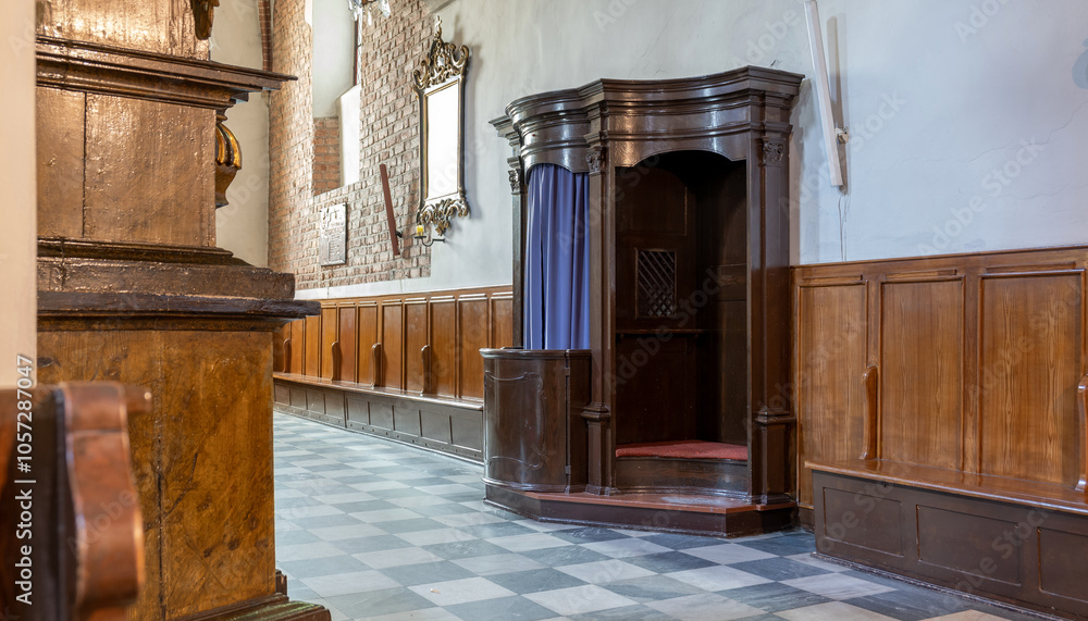 Lone empty wooden confession booth in traditional church interior ...