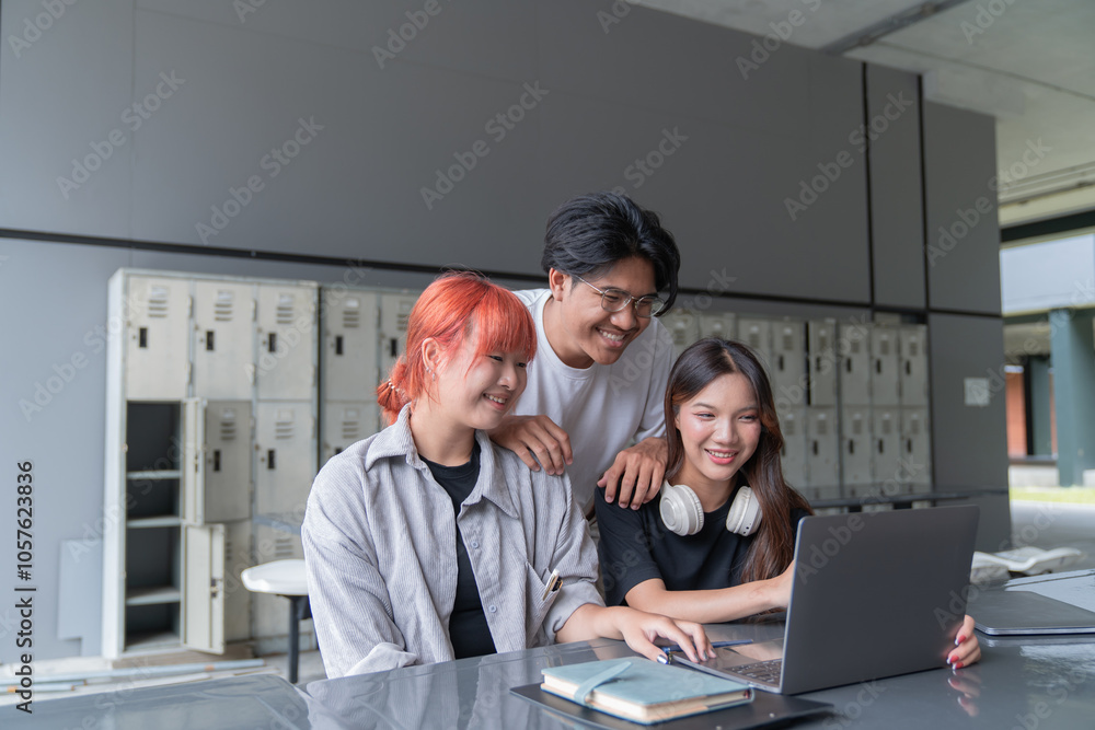 Three young asian university students are working together on a project ...