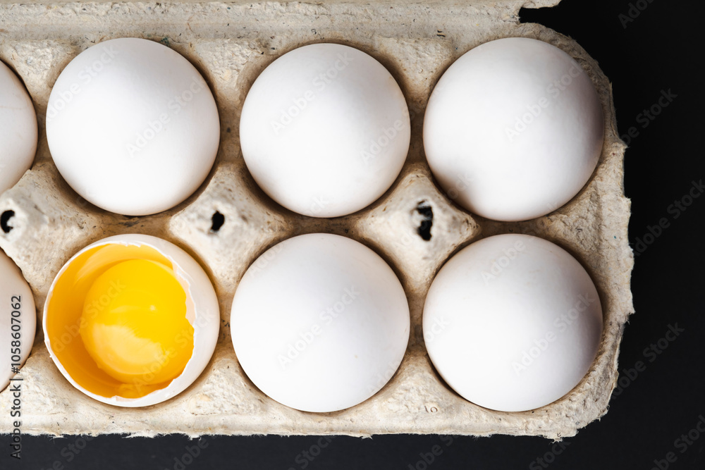 View of white eggs in a carton in an angled horizontal layout. Crack ...