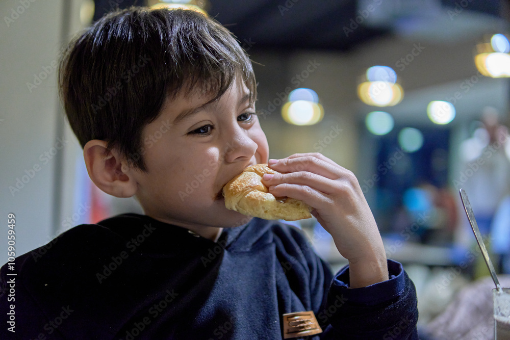 latin boy in profile in a bar with lights in the background having a ...