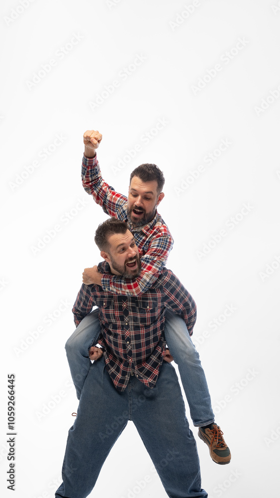 Two identical men, twin brothers having fun together, one man sitting ...