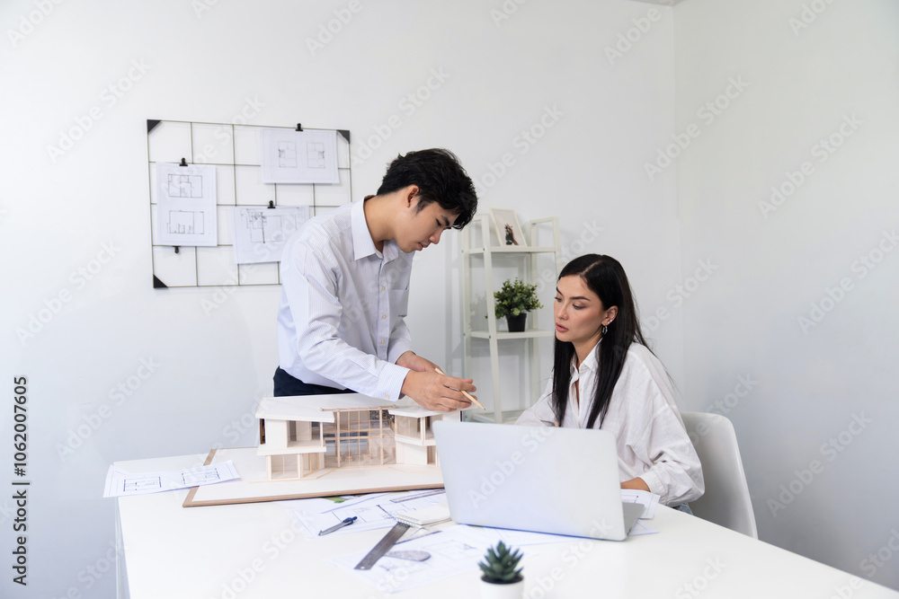 Professional male asian architect using ruler to measure house model ...