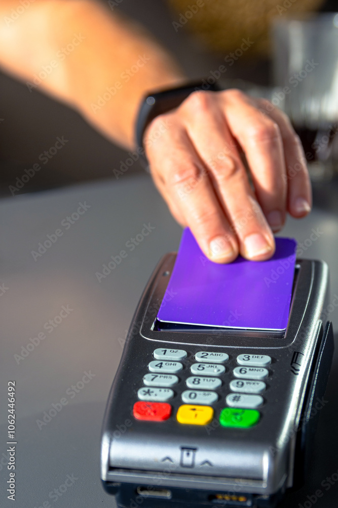 Person tapping credit card on payment terminal for contactless payment ...