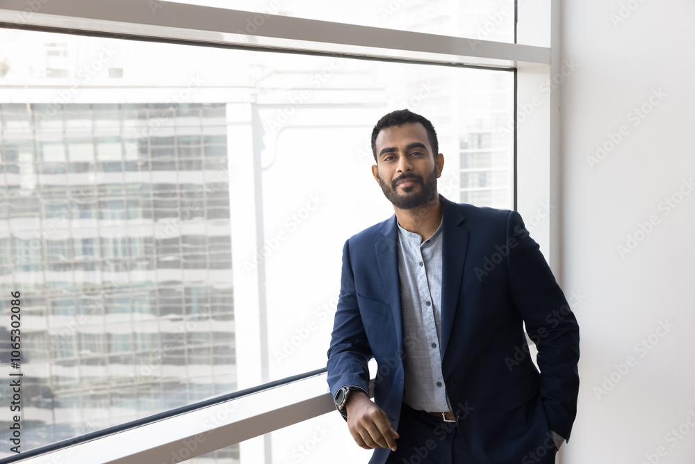 Positive confident young Indian manager man standing at large office ...